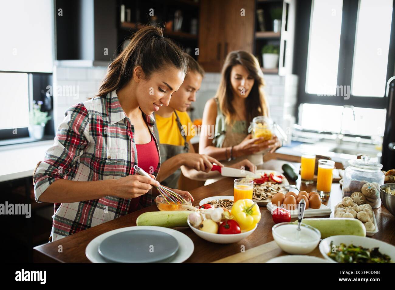 Beautiful happy people, friends is smiling while cooking together in ...