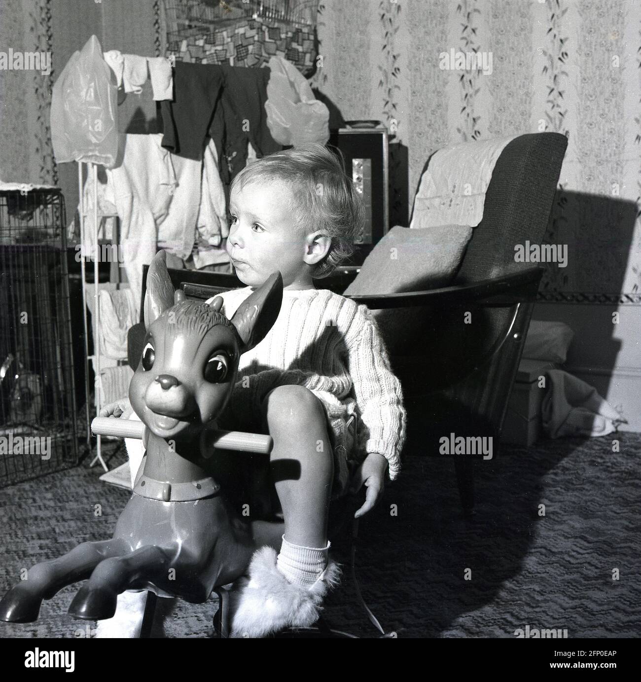 1960s, historical, inside a front room, an infant boy sitting on his ...