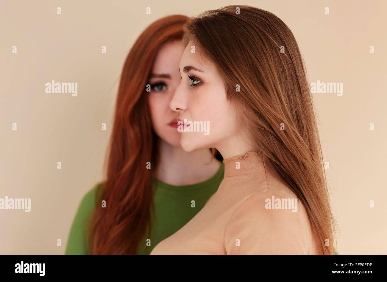 Profile of young female overlapping half of face of girlfriend against ...