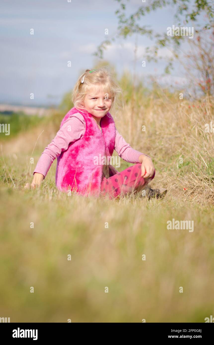 Girl sitting in grass hi-res stock photography and images - Alamy