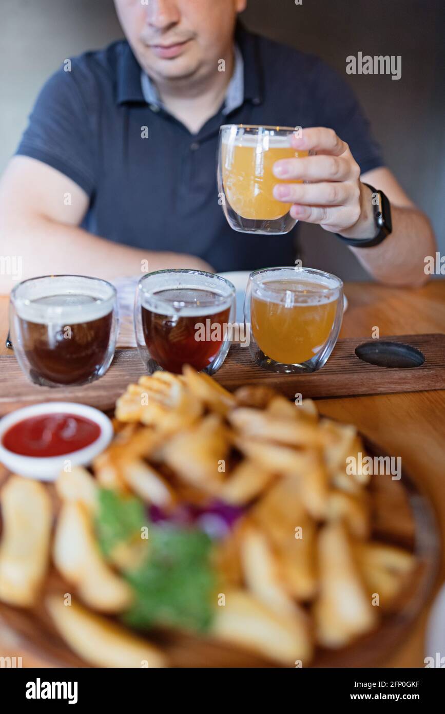 Man sampling variety of seasonal craft beer in pub. Beer samplers in ...