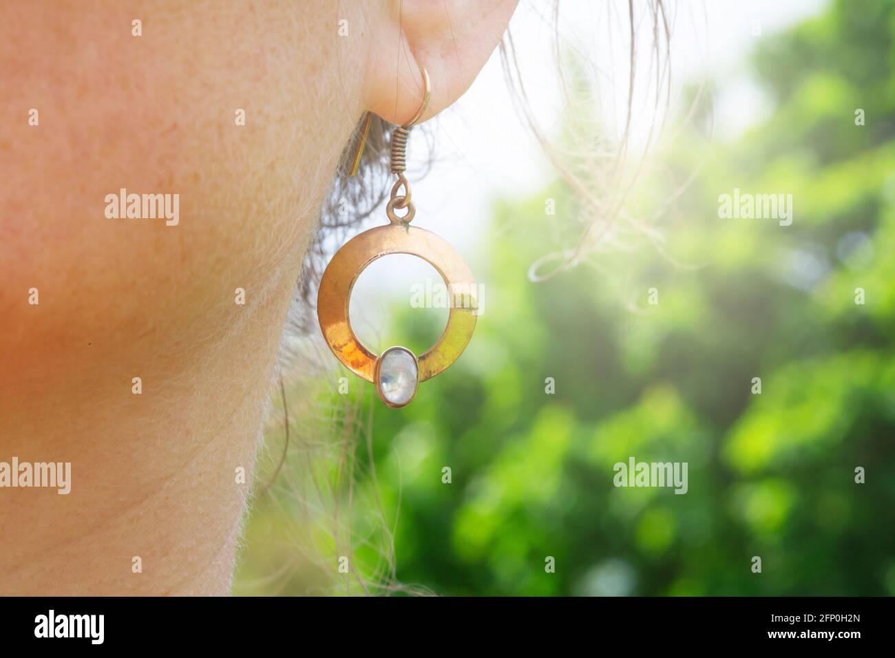 Outdoor detail of female ear wearing metal round shape earring Stock ...