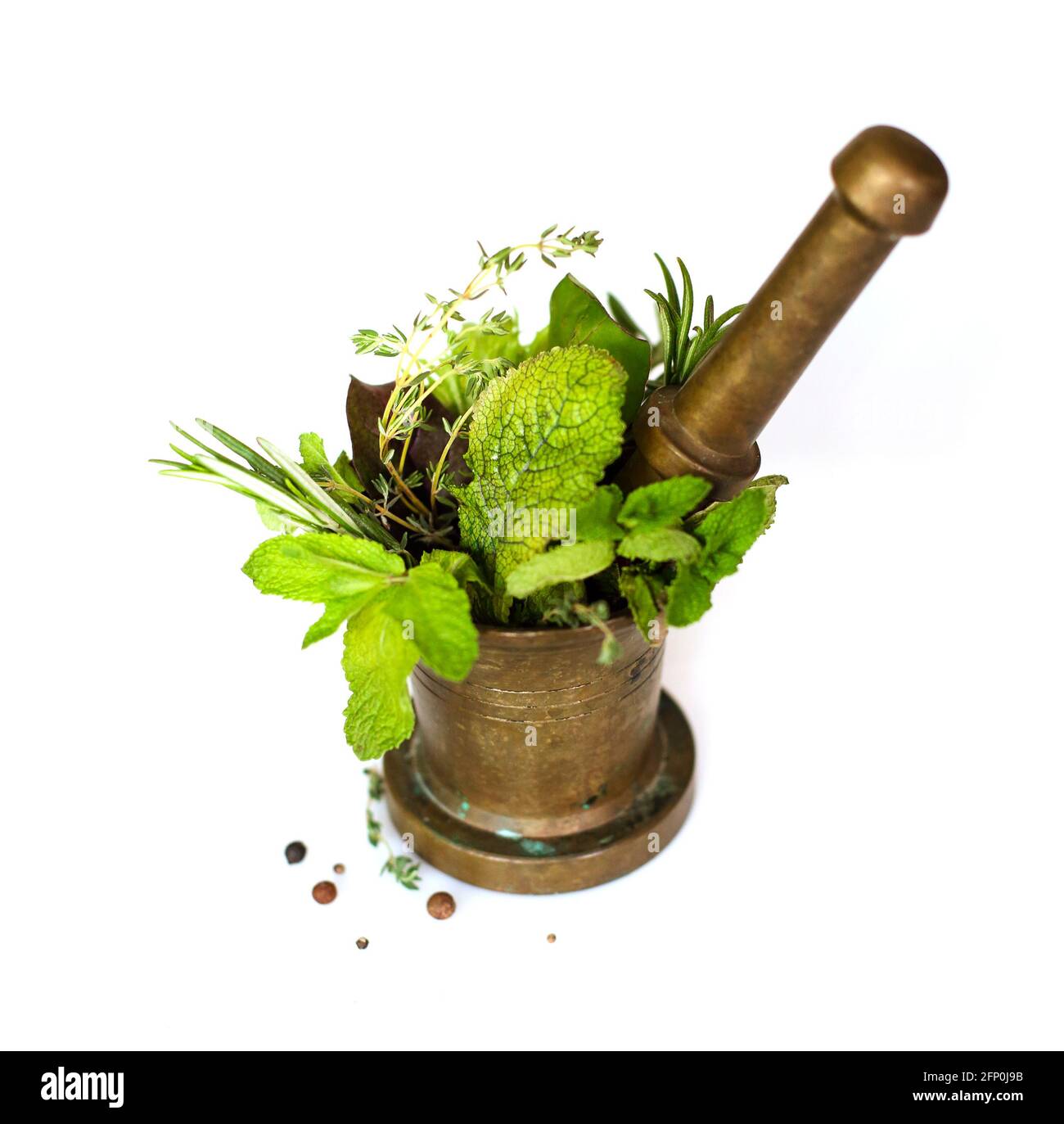 High angle of fresh herbs and pestle placed in bronze mortar isolated ...