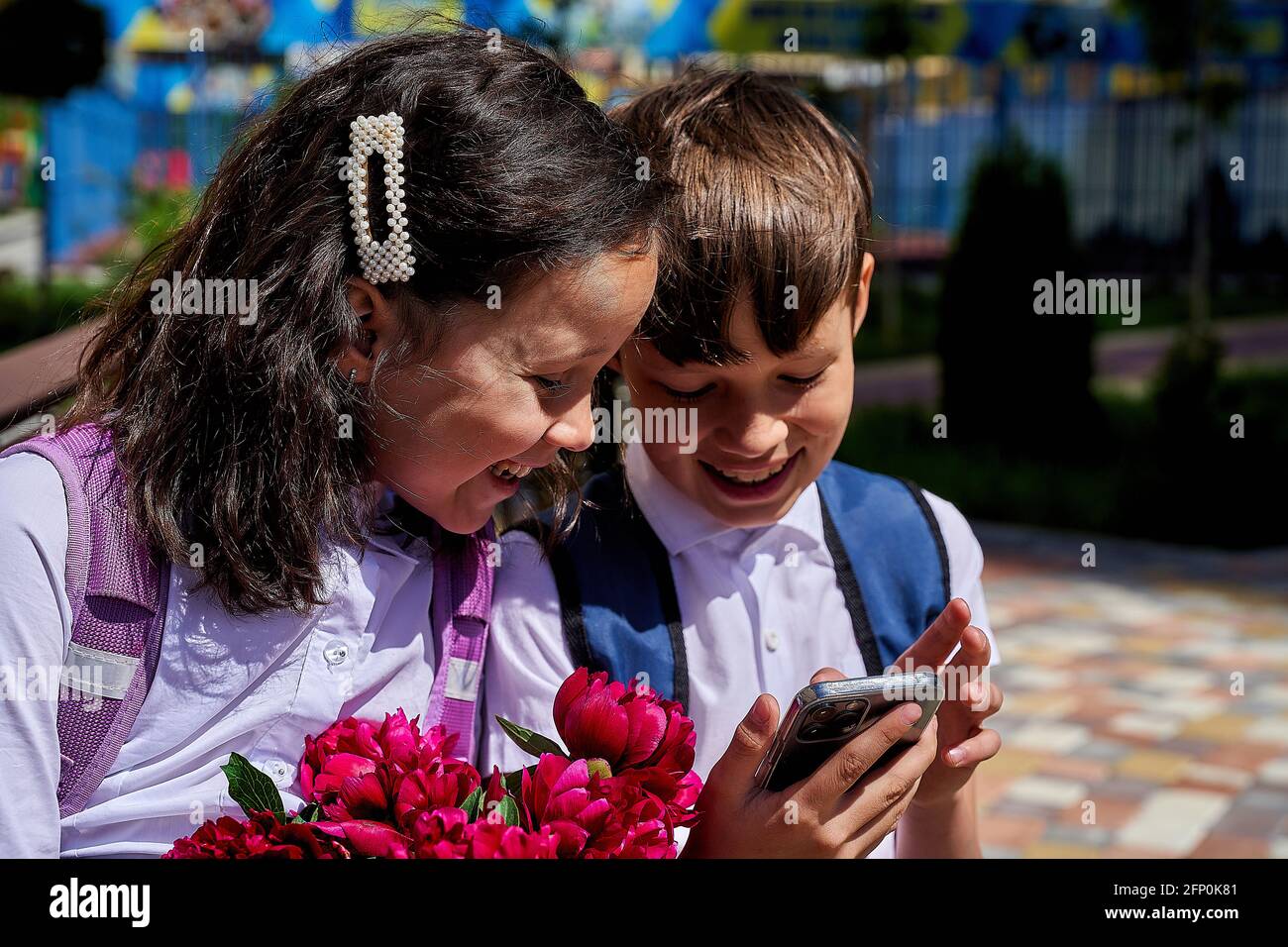 two small school children look at the phone Stock Photo - Alamy
