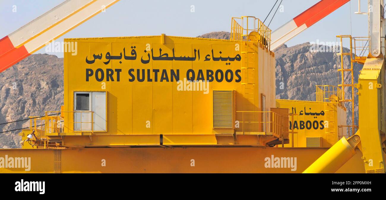 Port Sultan Qaboos bilingual signs on large yellow crane equipment ...