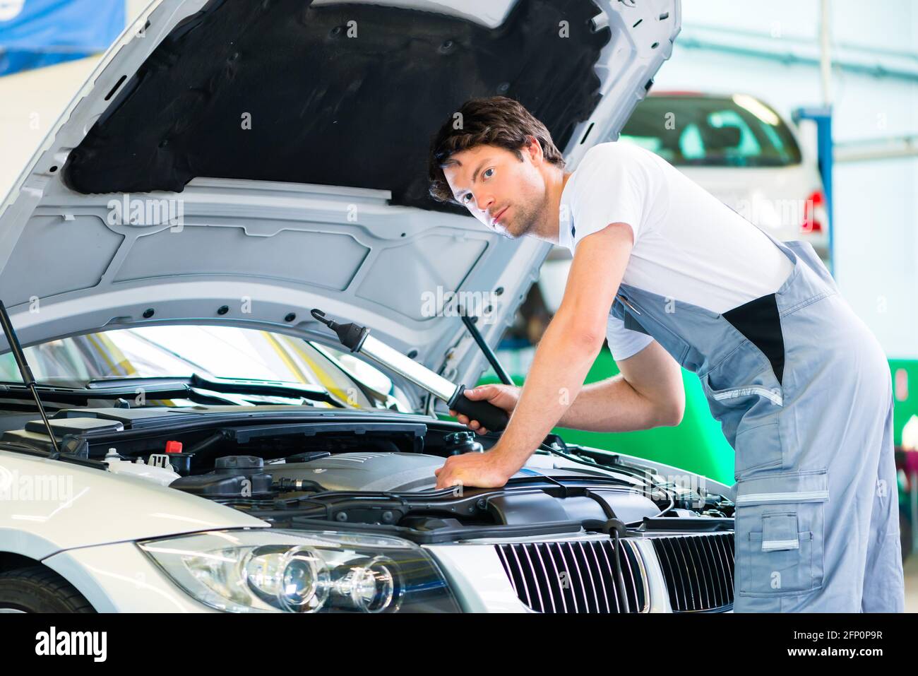 Auto mechanic working on car in service workshop Stock Photo - Alamy