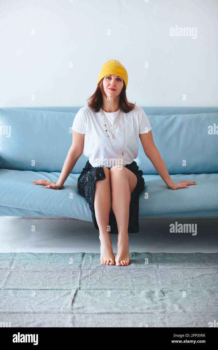 Woman sitting on couch barefoot hi-res stock photography and images - Alamy