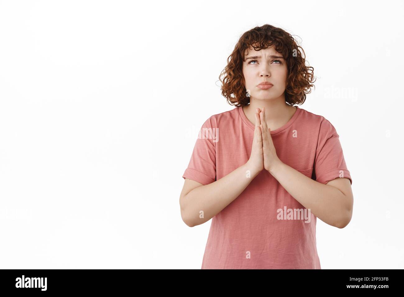 Sad and gloomy curly-haired girl pleading, begging and sulking, looking ...
