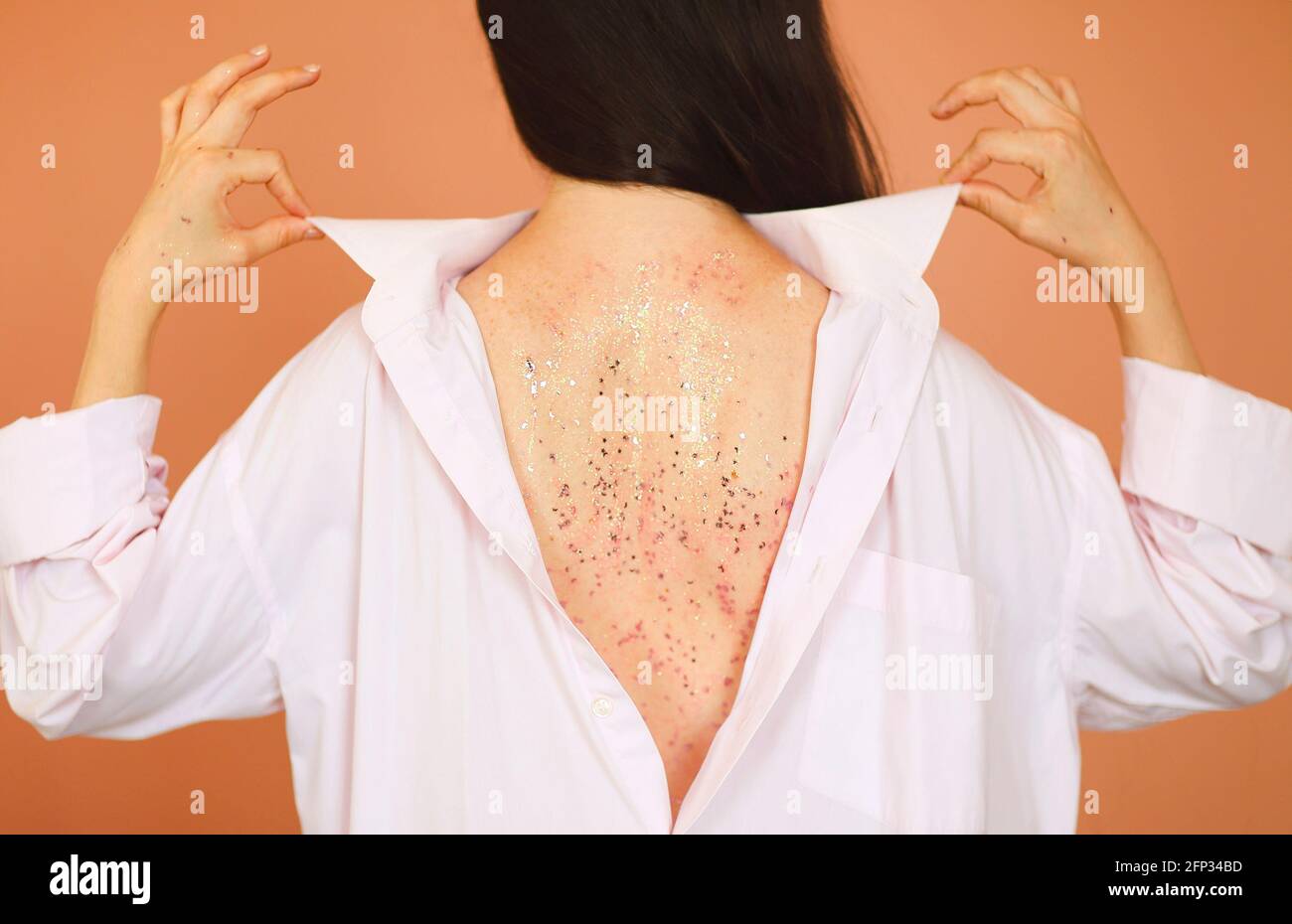 Back view of young female in white clothes revealing back with shiny ...
