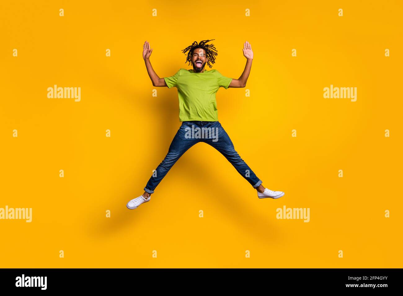 Full length photo portrait of excited guy jumping up spreading arms ...