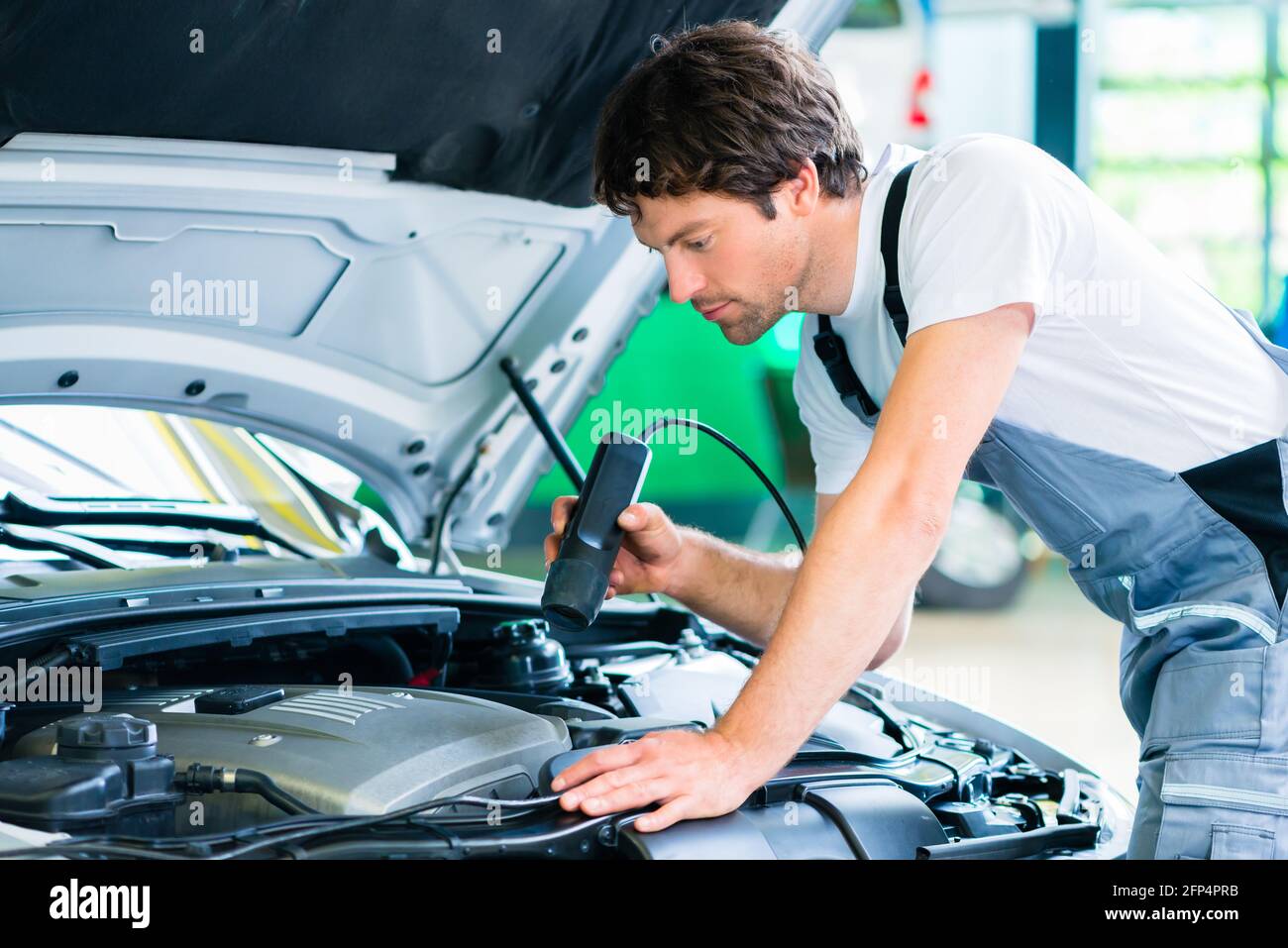 Mechanic man with diagnostic tool in car workshop Stock Photo - Alamy