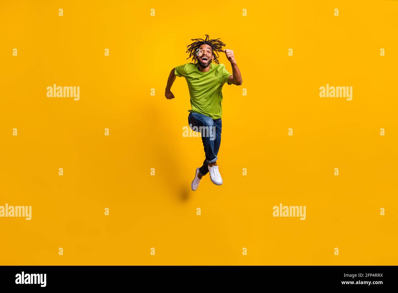 Full length photo portrait of man running forward laughing jumping up ...