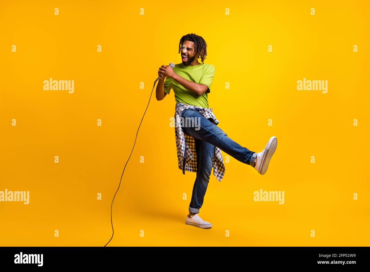 Full length photo portrait of man singing into mic standing on one leg ...
