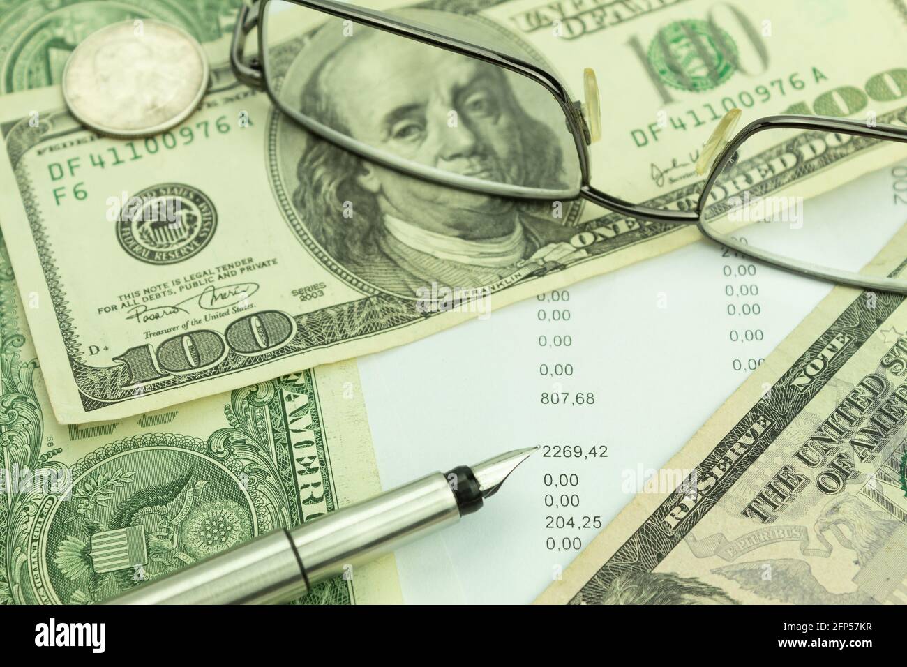 Dollar banknotes and glasses on the table. Forms with numbers on the ...