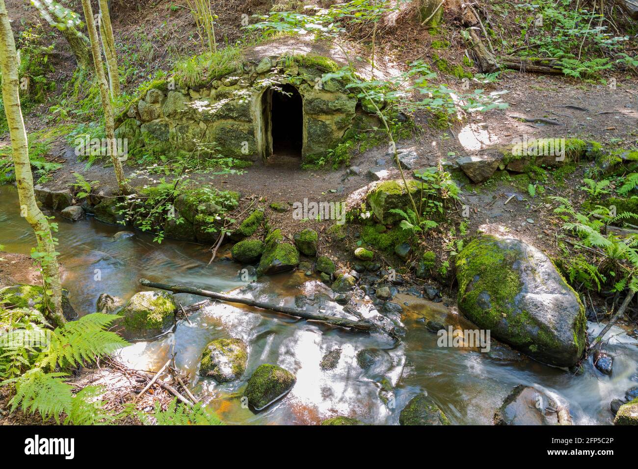 Beautiful nature landscape view. Entrance to abandoned cave and water ...
