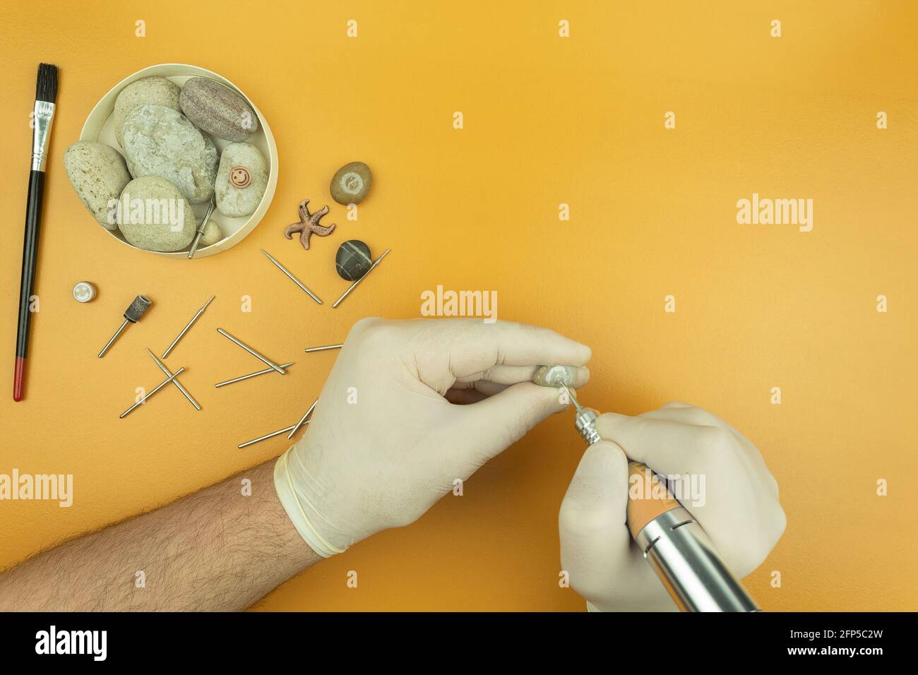 Stone processing with an engraving machine. The man's hands are ...