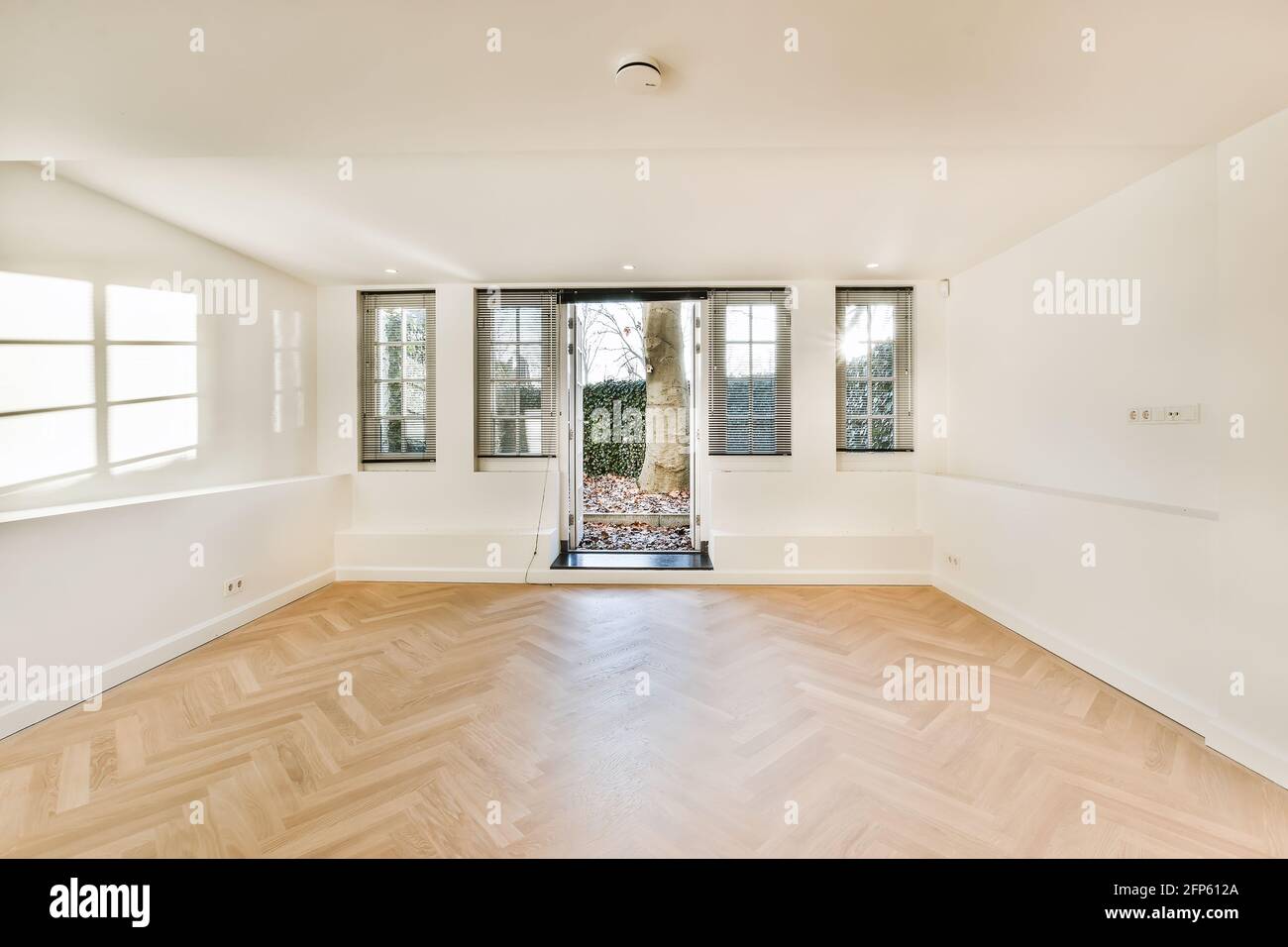 Interior of light house room with parquet floor and white walls and ...