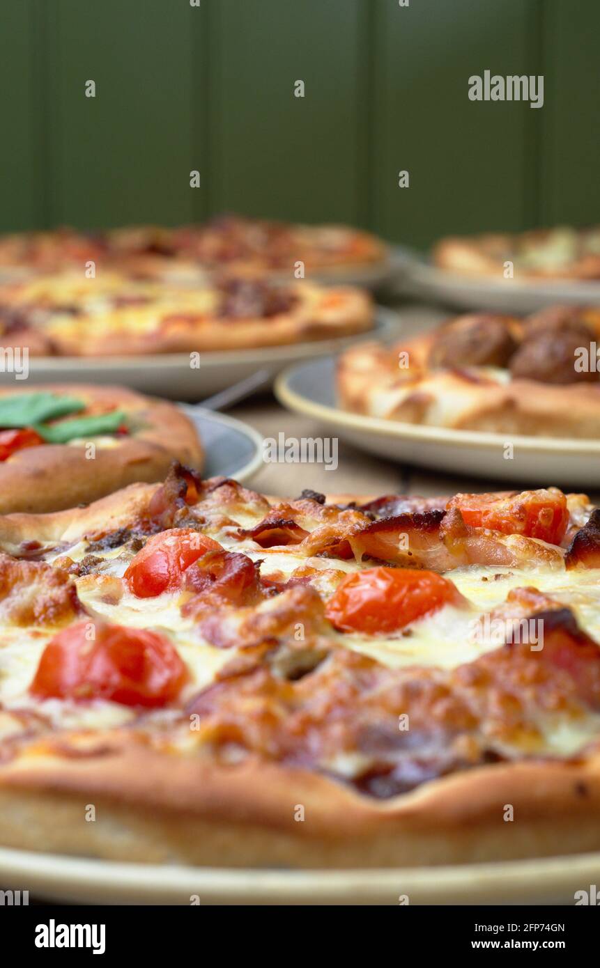 Pizzas. Focus is on the pizza toppings on the front pizza Stock Photo ...