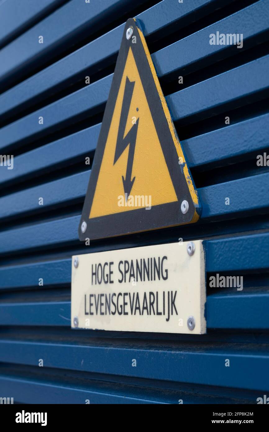 Electrical hazard sign on a triangular yellow sign mounted on a dark ...