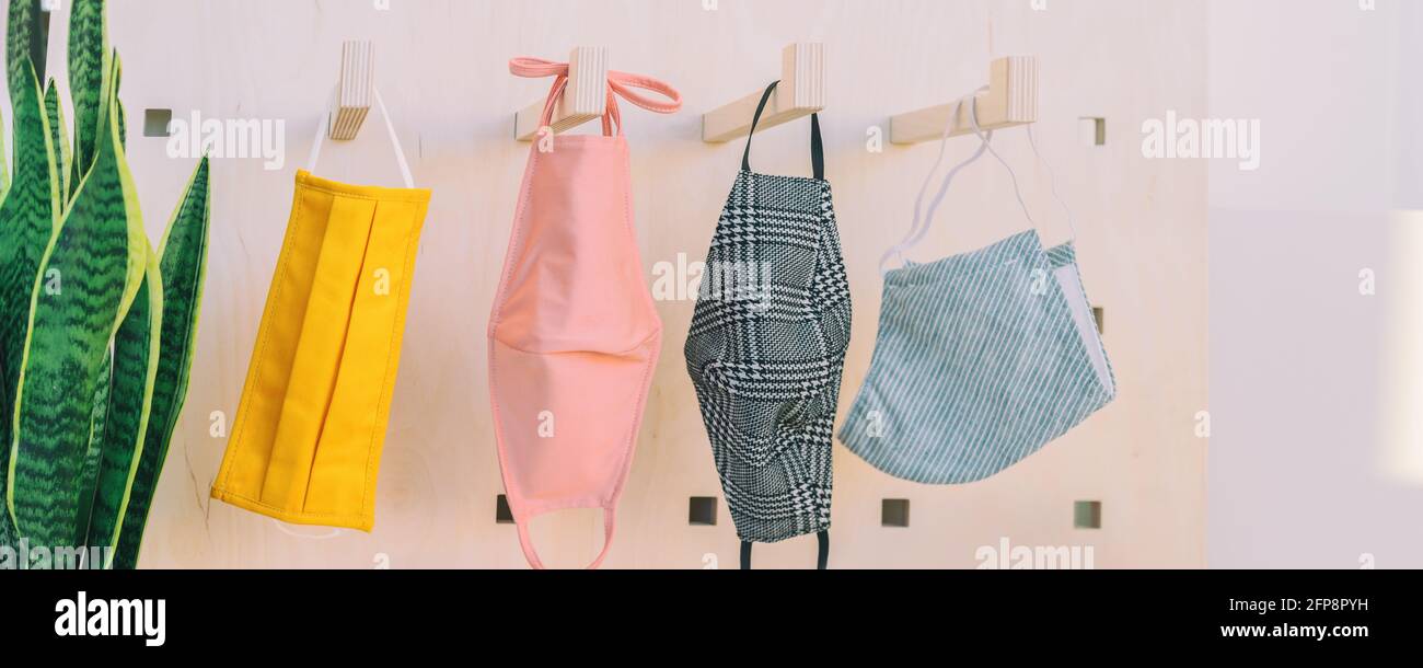 Fabric face masks hanging on closet hooks. Many colors and patterns to ...