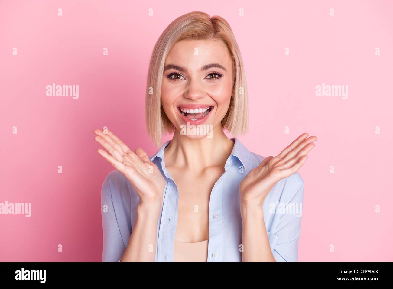 Photo of cheerful pretty nice young woman raise hands palms smile ...