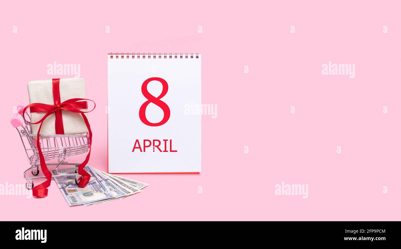 8th day of april. A gift box in a shopping trolley, dollars and a ...