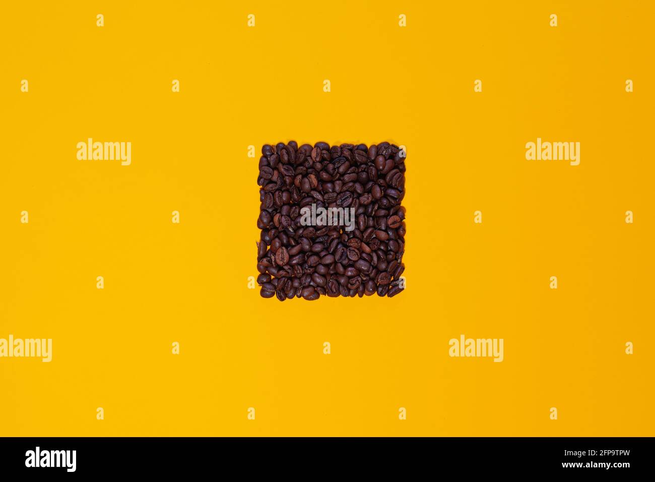 Coffee beans grouped in a rectangle isolated on a yellow background ...