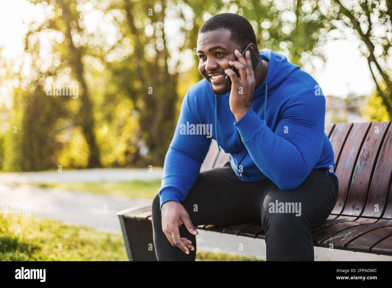 Man using mobile phone while resting after exercise on bench Stock ...