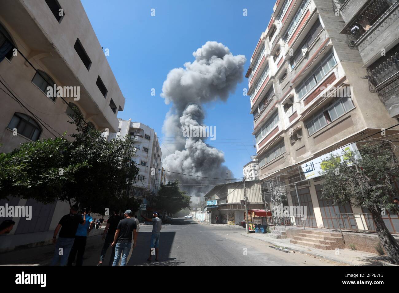 Smoke rises from a 14-story building as Israeli fighter jets continue ...