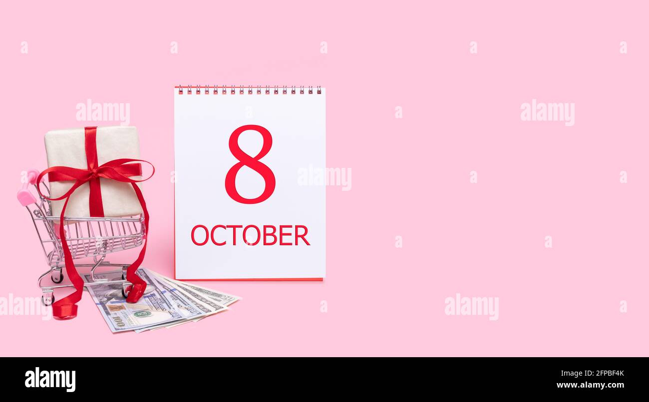 8th day of october. A gift box in a shopping trolley, dollars and a ...