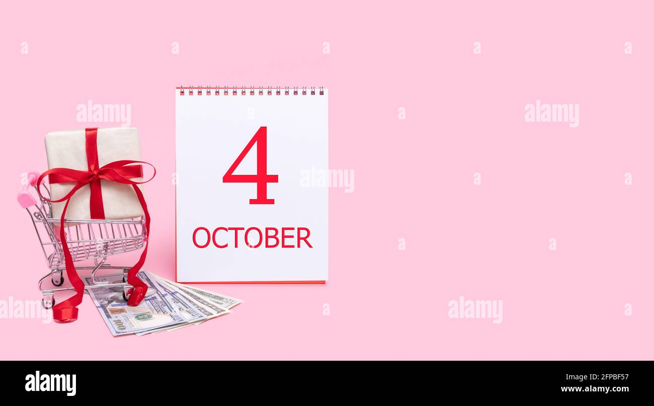4th day of october. A gift box in a shopping trolley, dollars and a ...