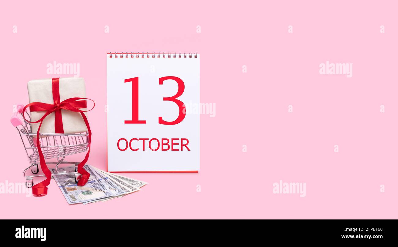 13th day of october. A gift box in a shopping trolley, dollars and a ...