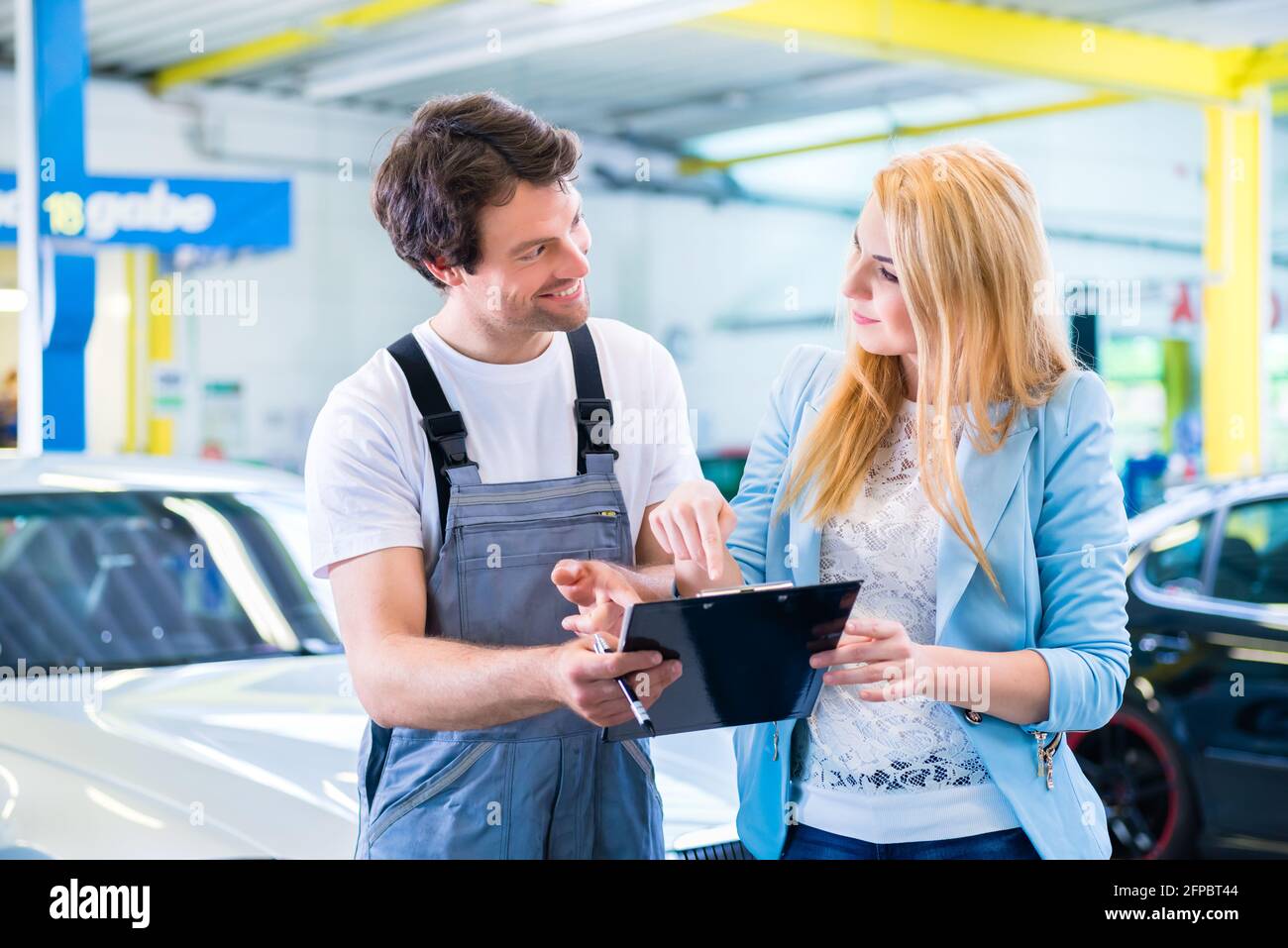 Male workshop mechanic handover car with checklist to client Stock ...