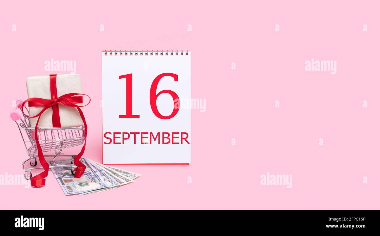 16th day of september. A gift box in a shopping trolley, dollars and a ...