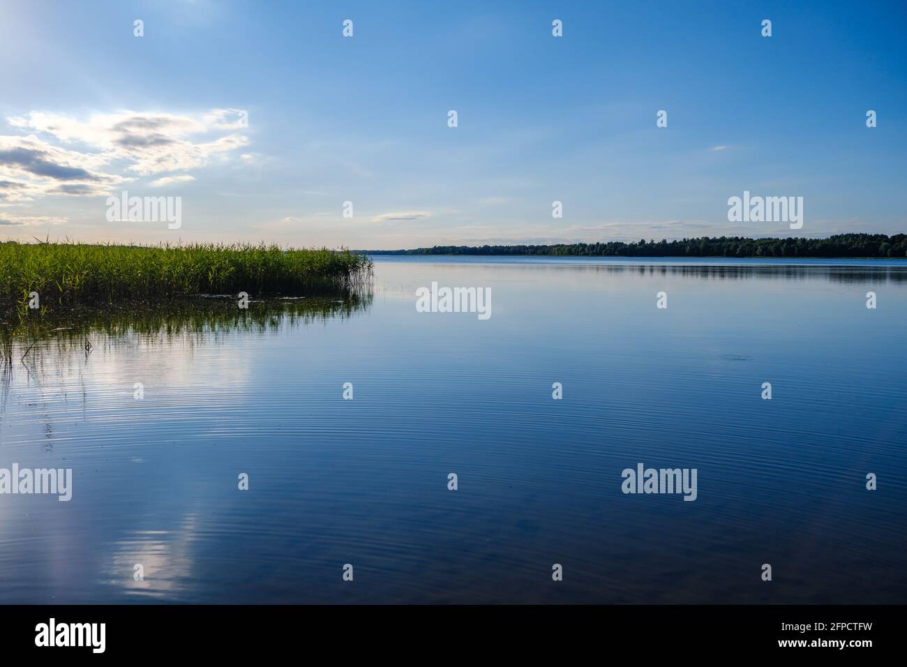 wide river landscape scene with large body of water, blue reflections ...
