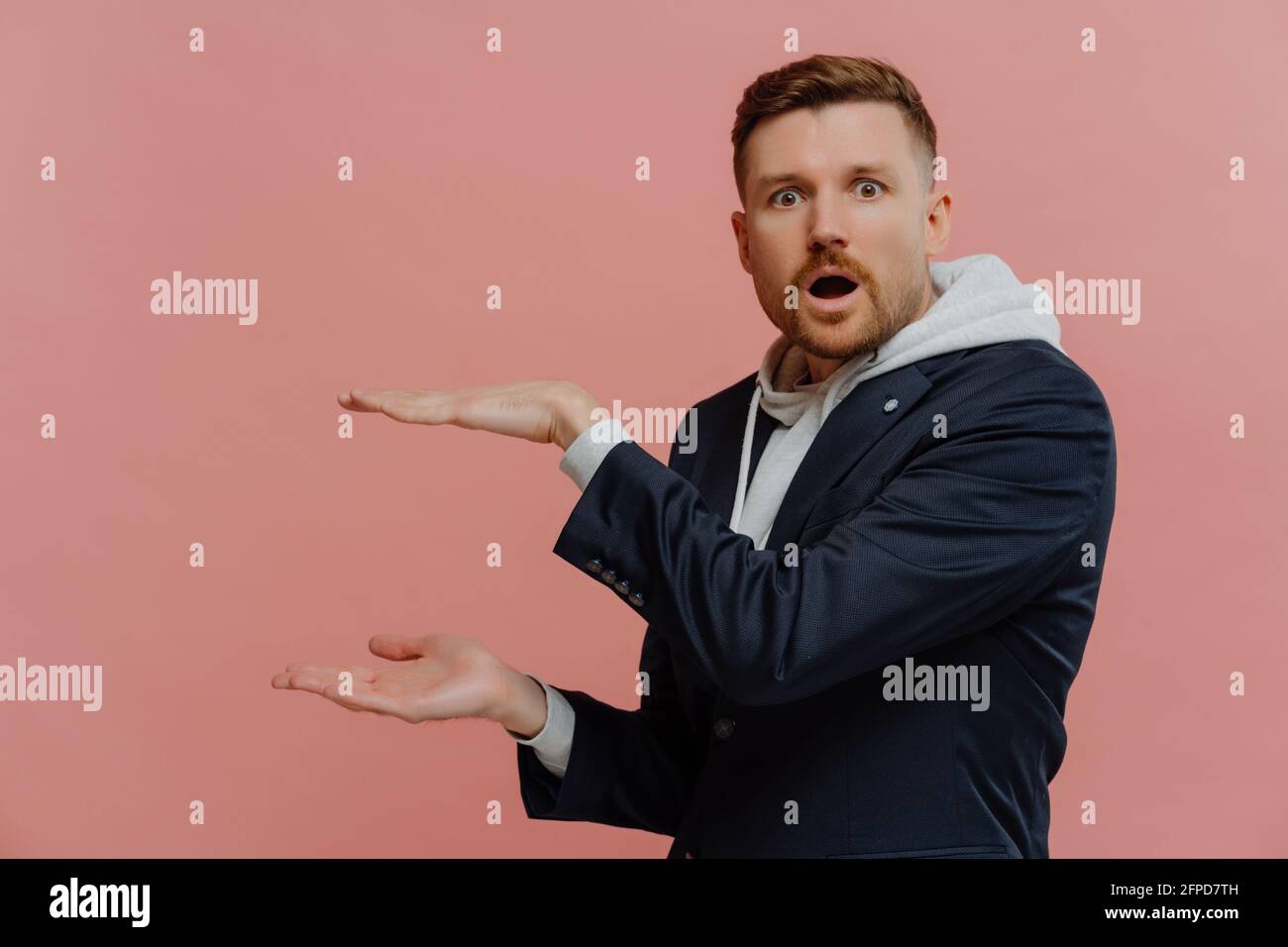 Impressed man presenting something and being in shock Stock Photo - Alamy
