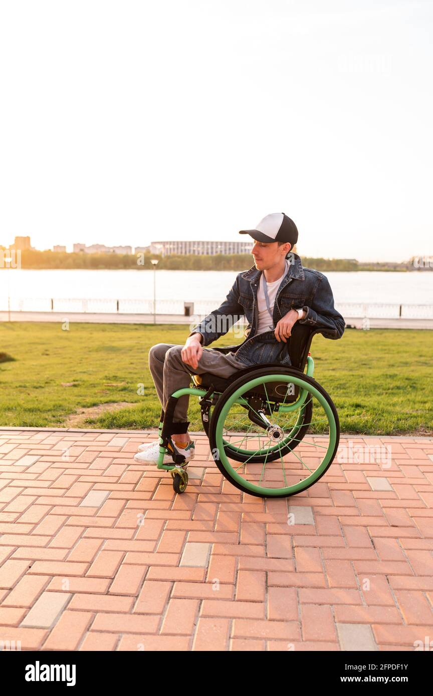 Invalid man sitting on a wheel chair and enjoying a walk outdoors Stock ...