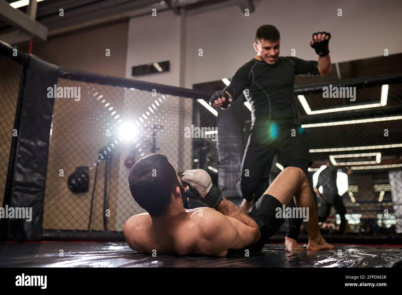 Mixed martial artist man in black wear win, stand over the losing ...