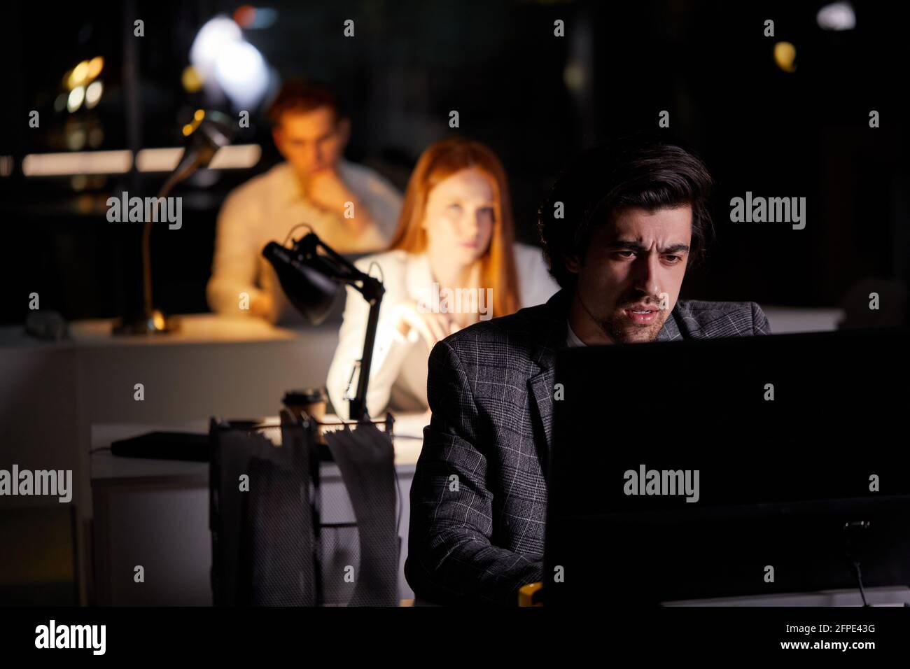 Determined businessman concentrated hard on difficult computer task ...