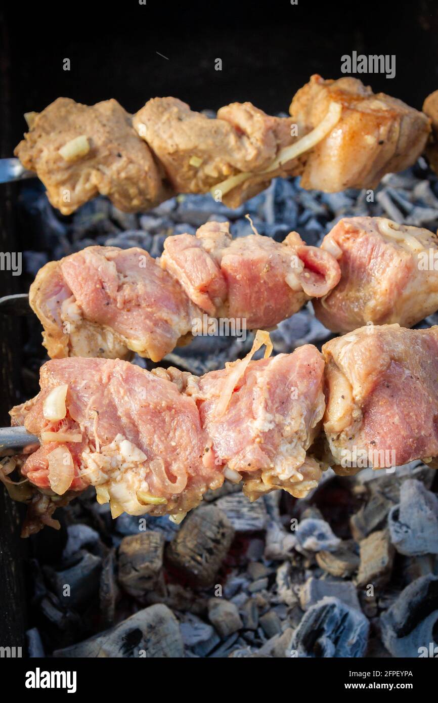 Shish Kebab made from pieces of pork is cooked on skewers on the grill ...