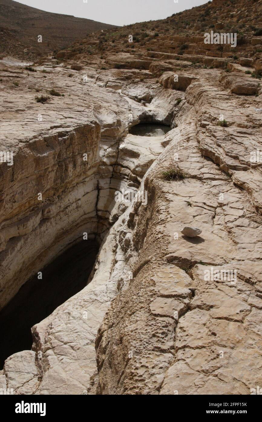 Water pool or rain pool in a hole in a dry riverbed rock in the Negev ...