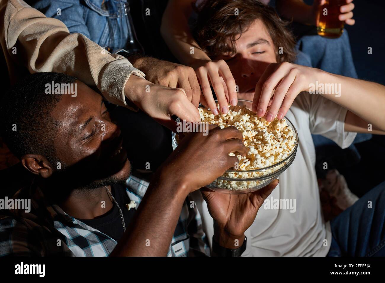 Fun Movie with Friends. Group of people eating popcorn while watching ...