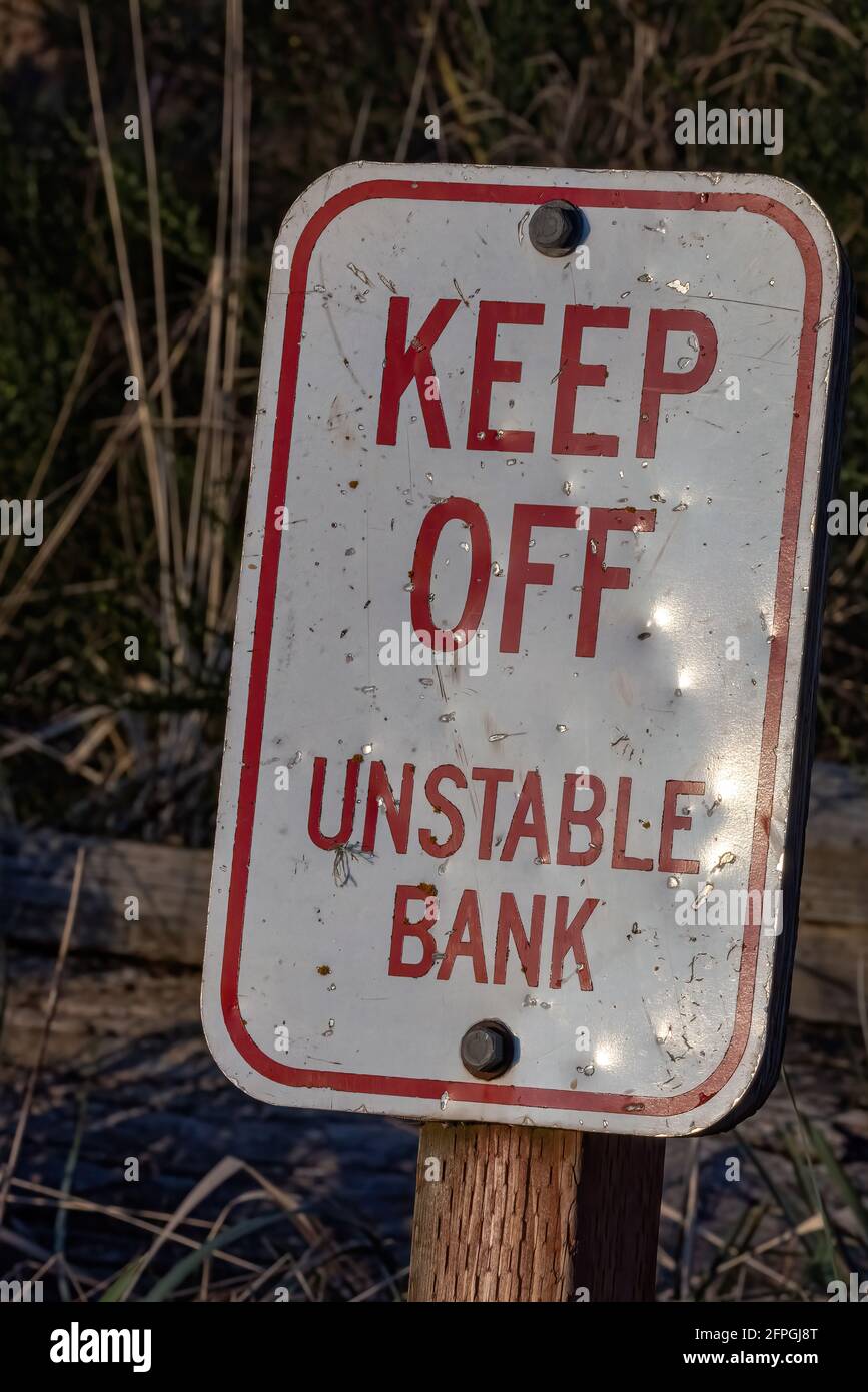 A red and white warning sign to keep off the unstable area for safety ...