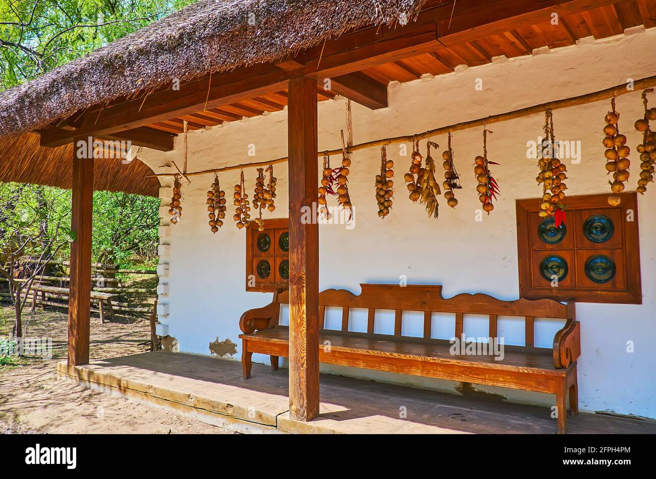 The shady porch of shynok bar-restaurant with wooden bench, pillars and ...