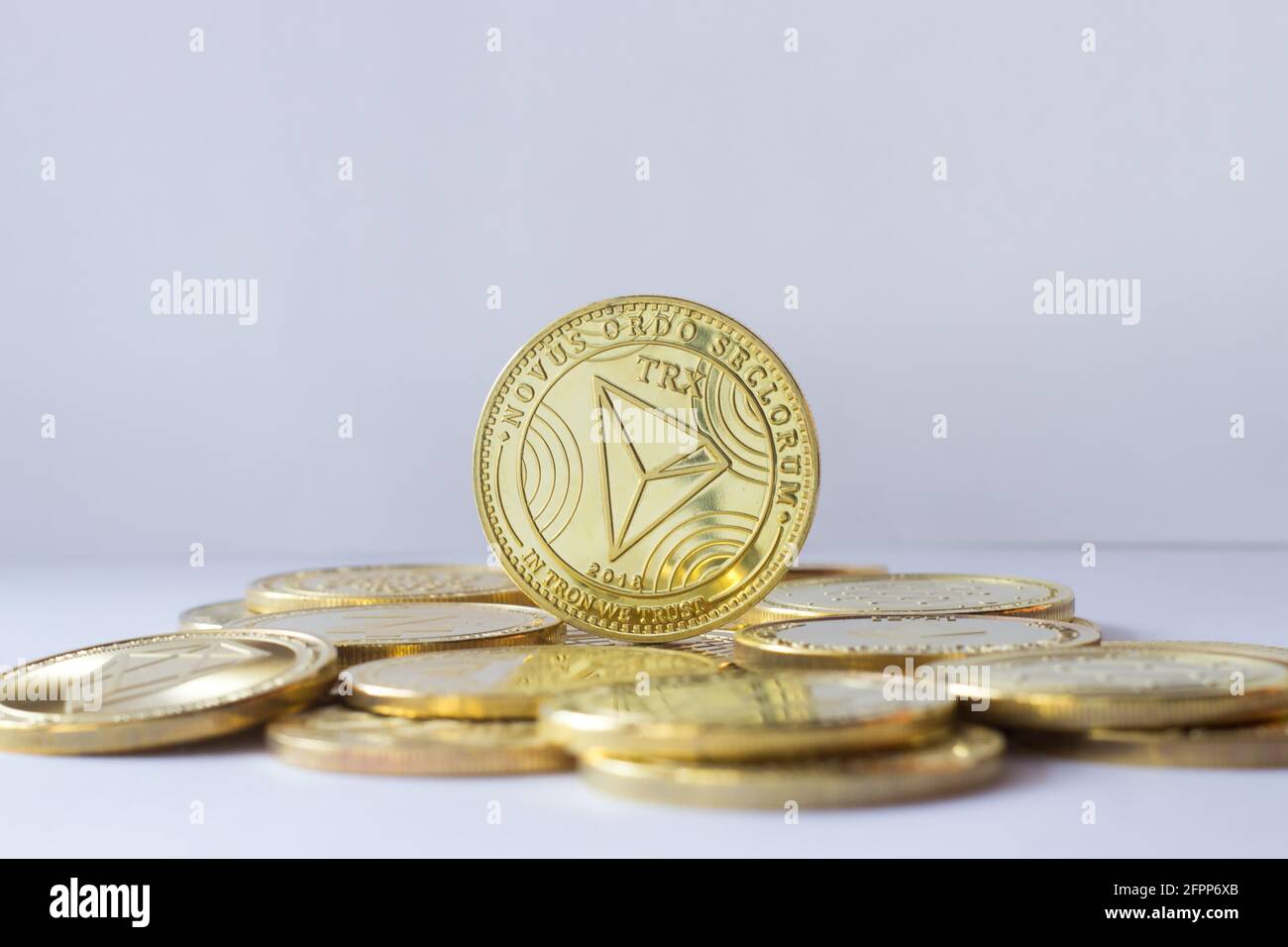 Tron trx coin stand on other cryptocurrencies. Pale blue background ...