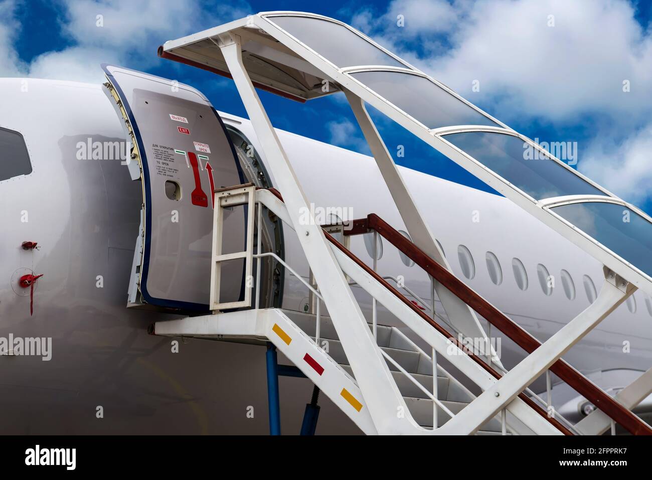Large passenger jet with ladder against the background of blue sky ...
