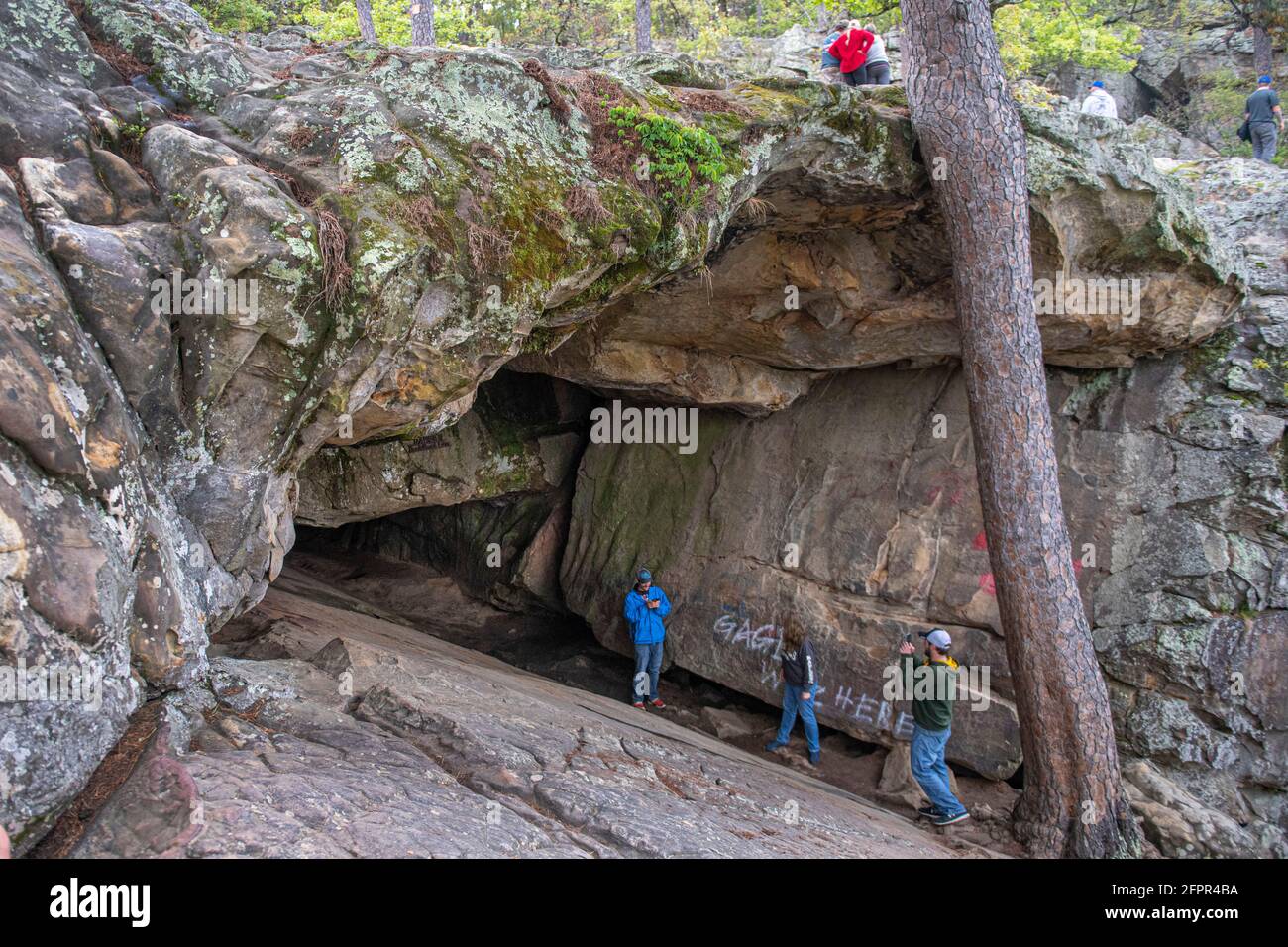 Visitors explore the entrance of Robbers Cave at Robbers Cave State ...