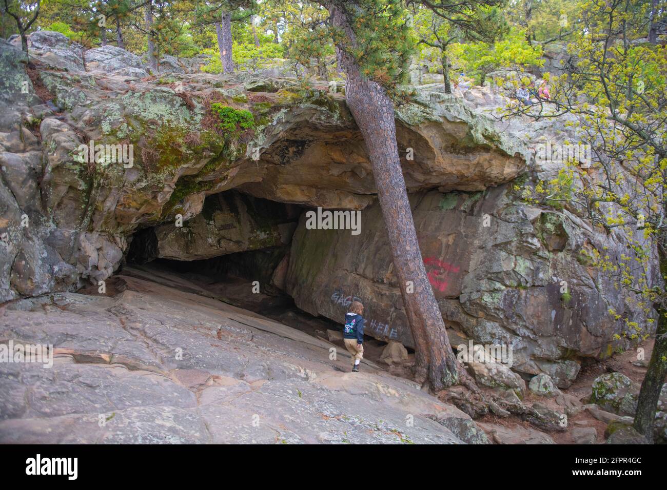 Visitors explore the entrance of Robbers Cave at Robbers Cave State ...