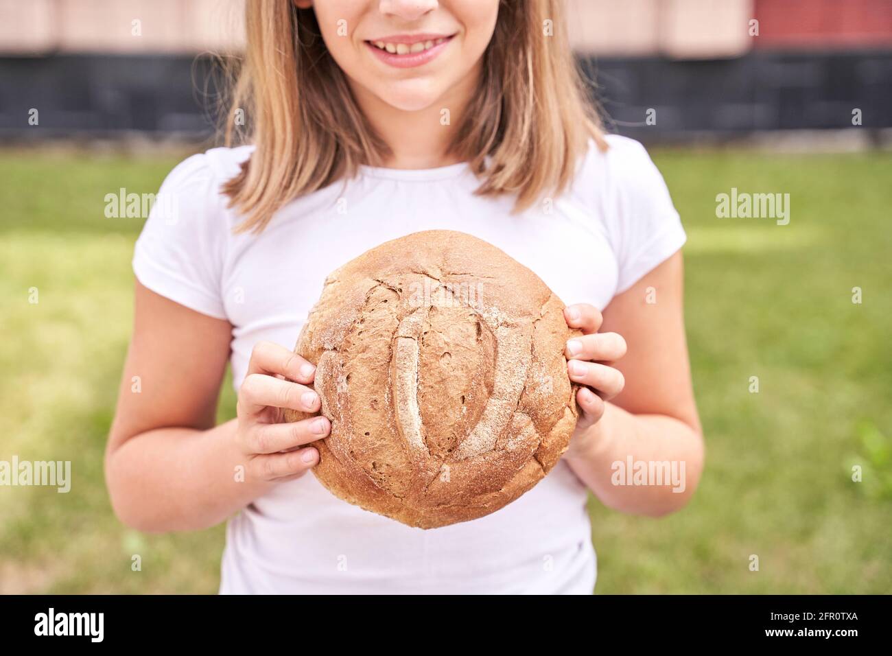 Child holds round bread. Healthy food. Carrying big fresh baker bun ...