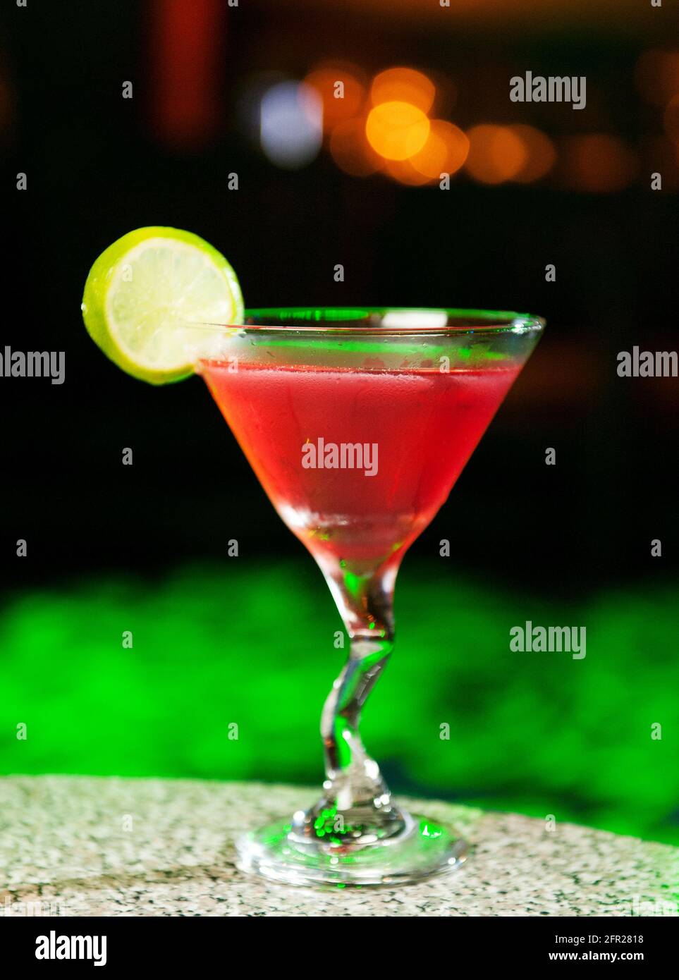A red Martini cocktail on a green background Stock Photo - Alamy